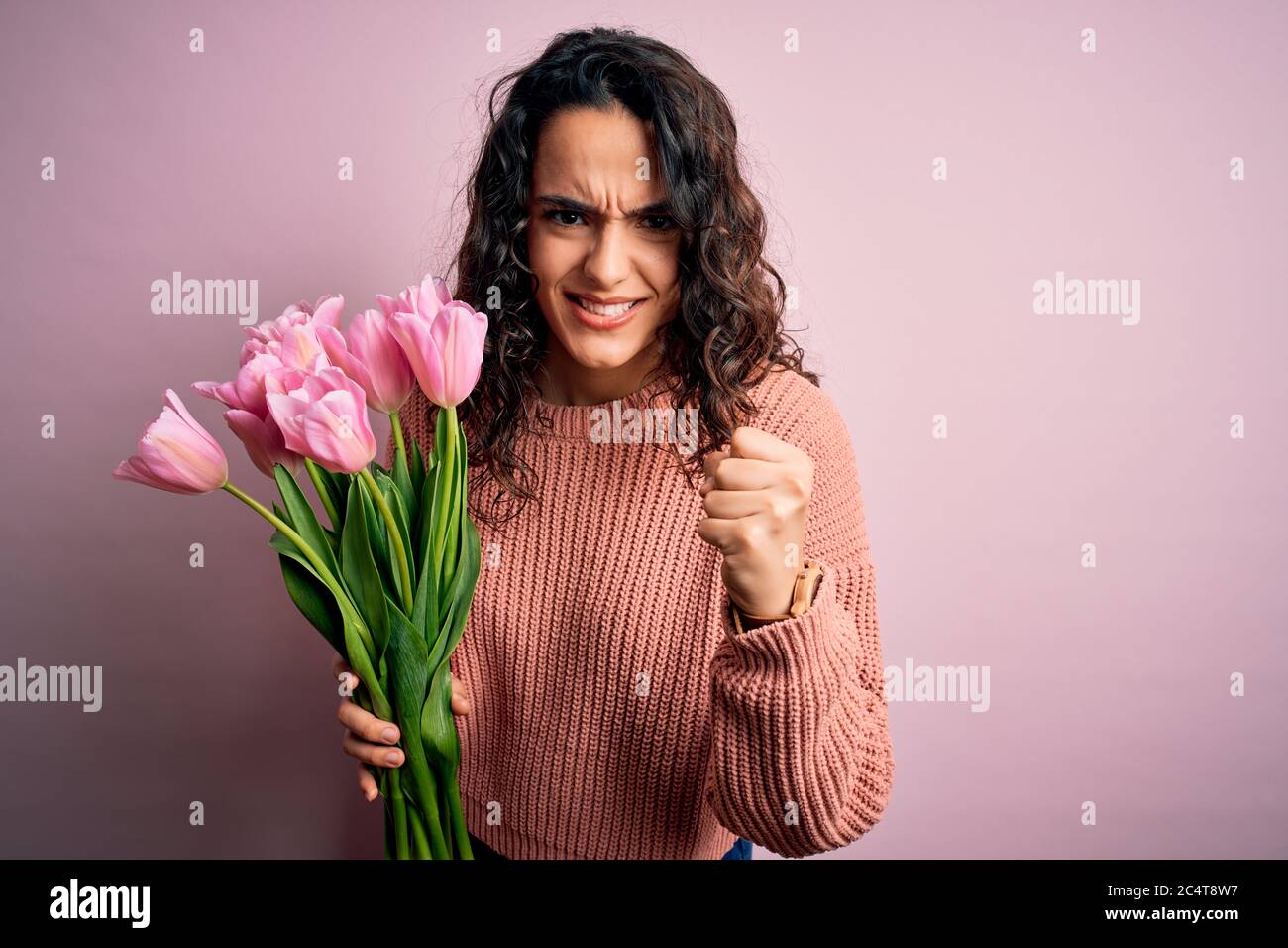 Young beautiful romantic woman with curly hair holding bouquet of pink ...
