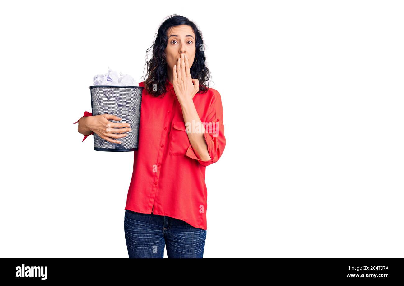 Young beautiful hispanic woman holding paper bin full of crumpled ...