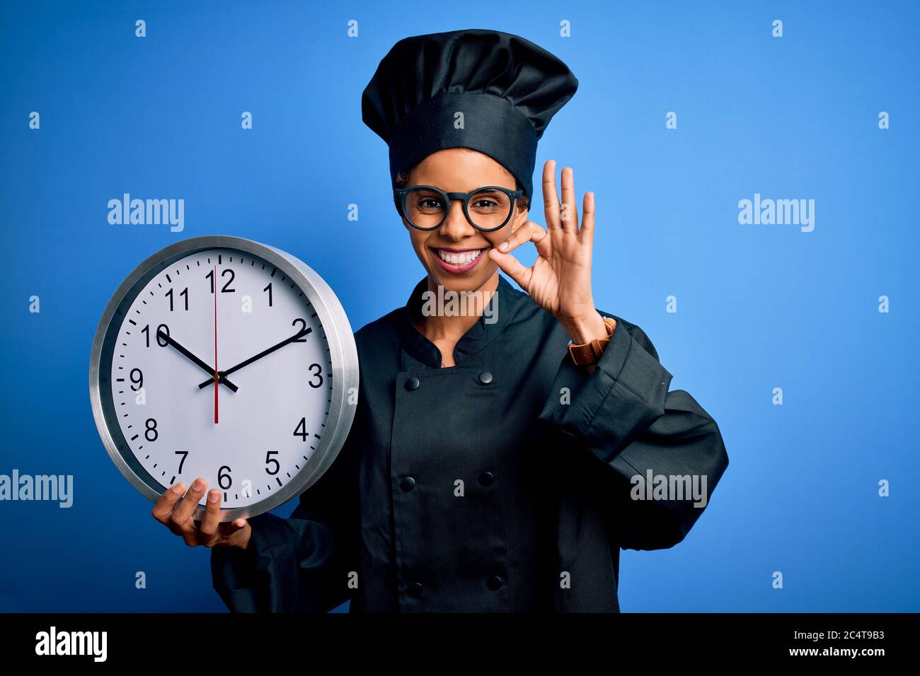 African american baker woman wearing cooker uniform and hat doing ...