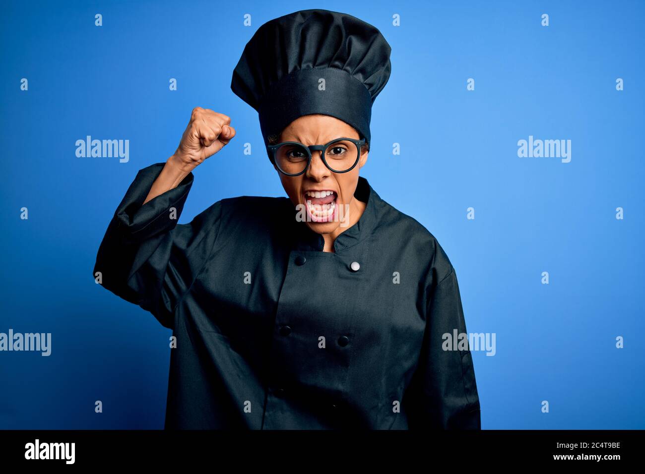 Young african american chef woman wearing cooker uniform and hat over ...