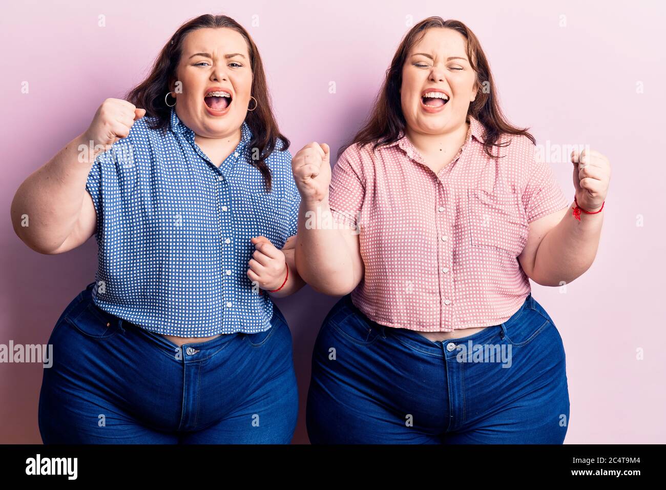 Young plus size twins wearing casual clothes angry and mad raising ...