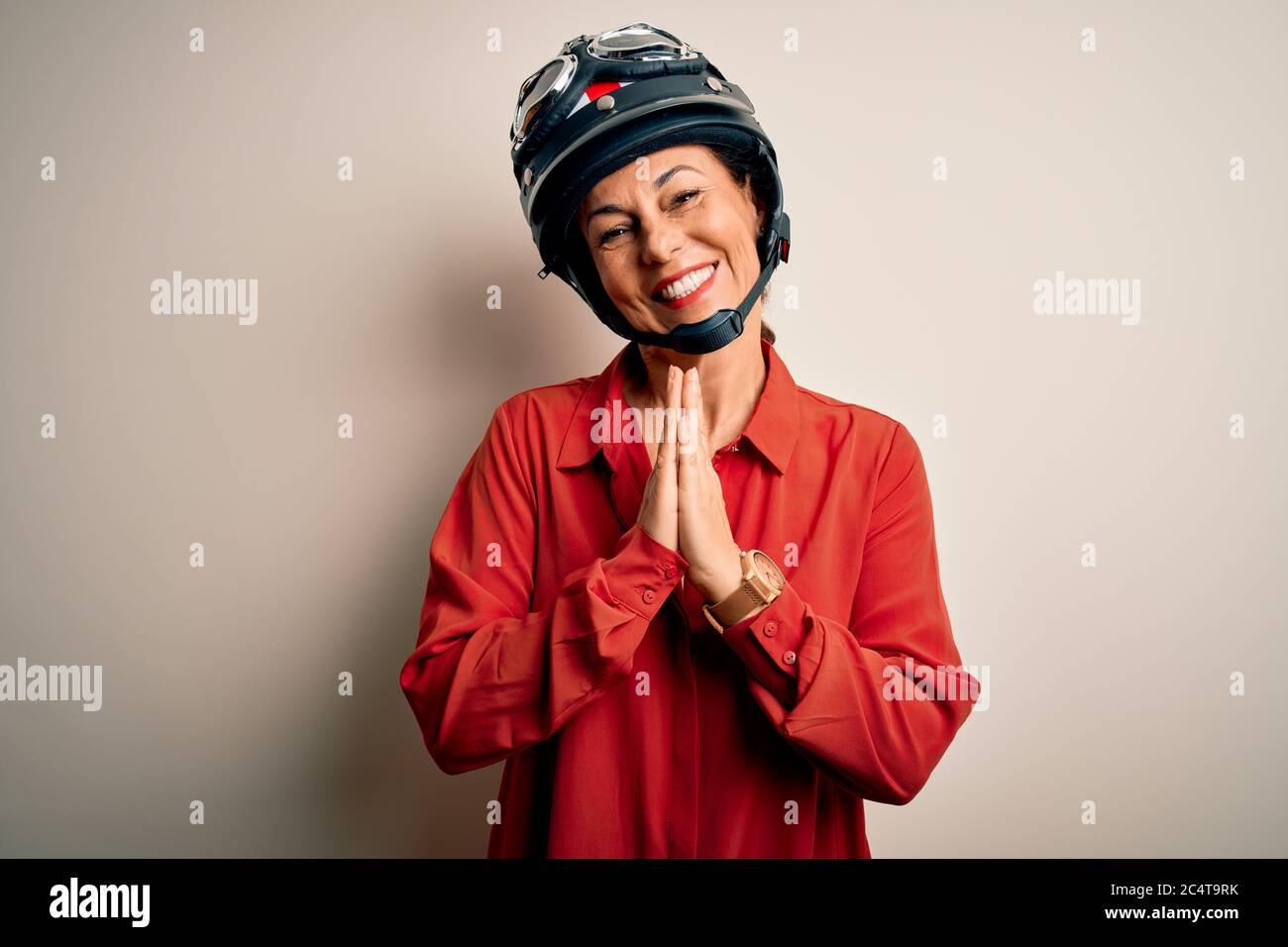 Middle age motorcyclist woman wearing motorcycle helmet over isolated ...