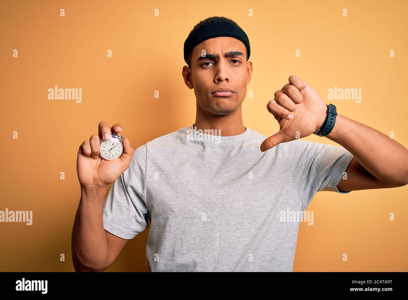 Young handsome african american man doing sport using stopwatch over ...