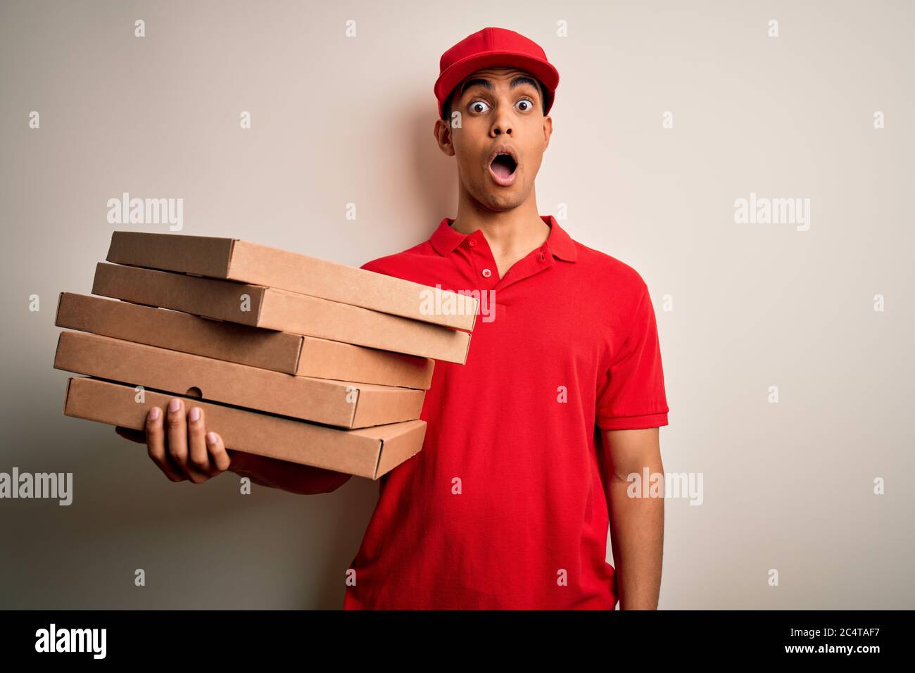 Handsome african american delivery man holding boxes of italian pizza ...