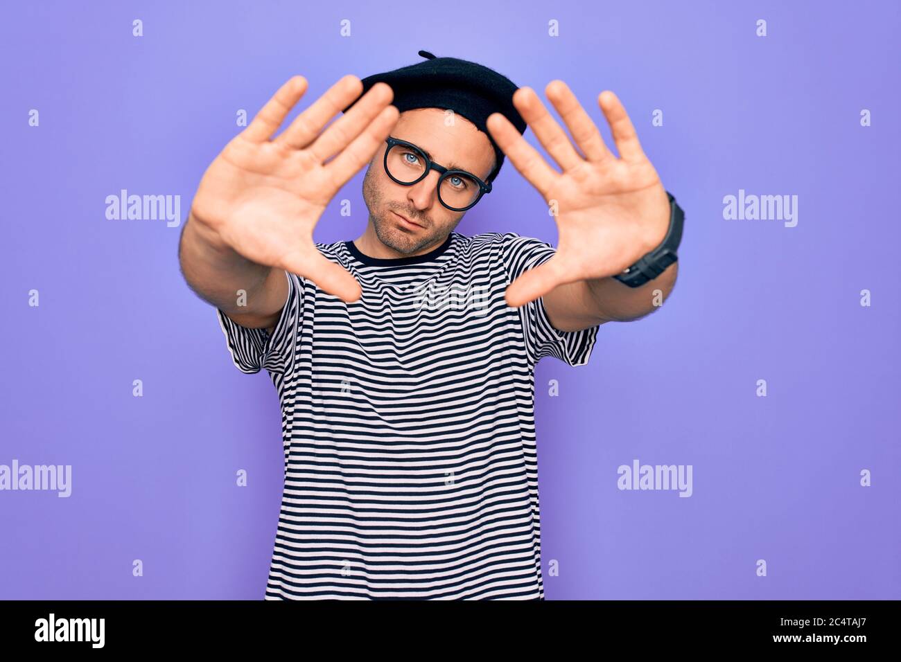 Handsome man with blue eyes wearing striped t-shirt and french beret ...