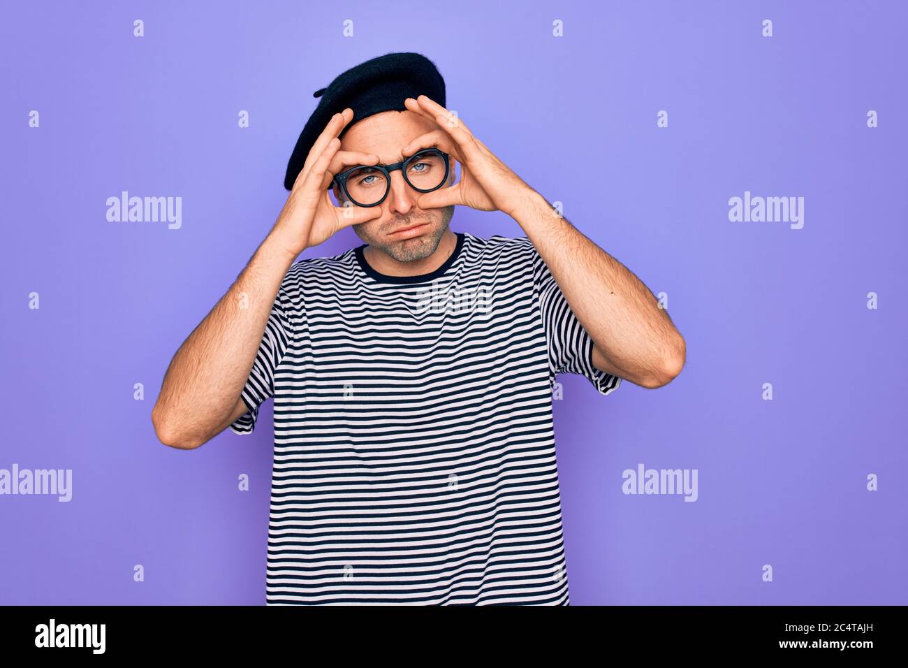 Handsome man with blue eyes wearing striped t-shirt and french beret ...