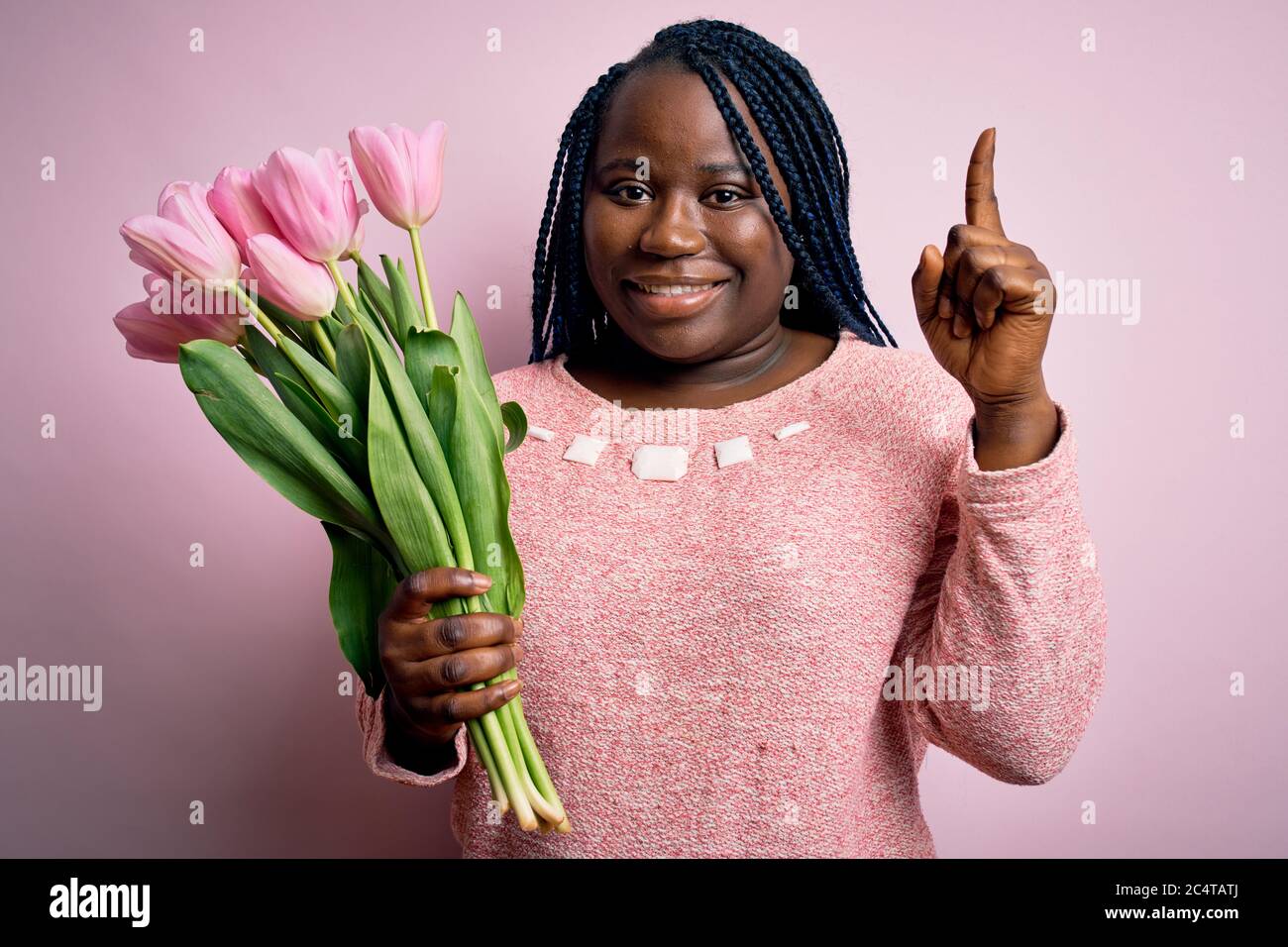 Young african american plus size woman with braids holding bouquet of ...