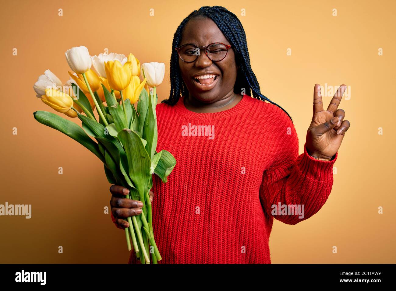 Young african american plus size woman with braids holding bouquet of ...