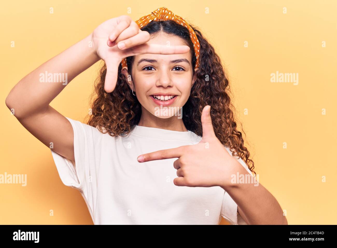 Beautiful kid girl with curly hair wearing casual clothes smiling ...