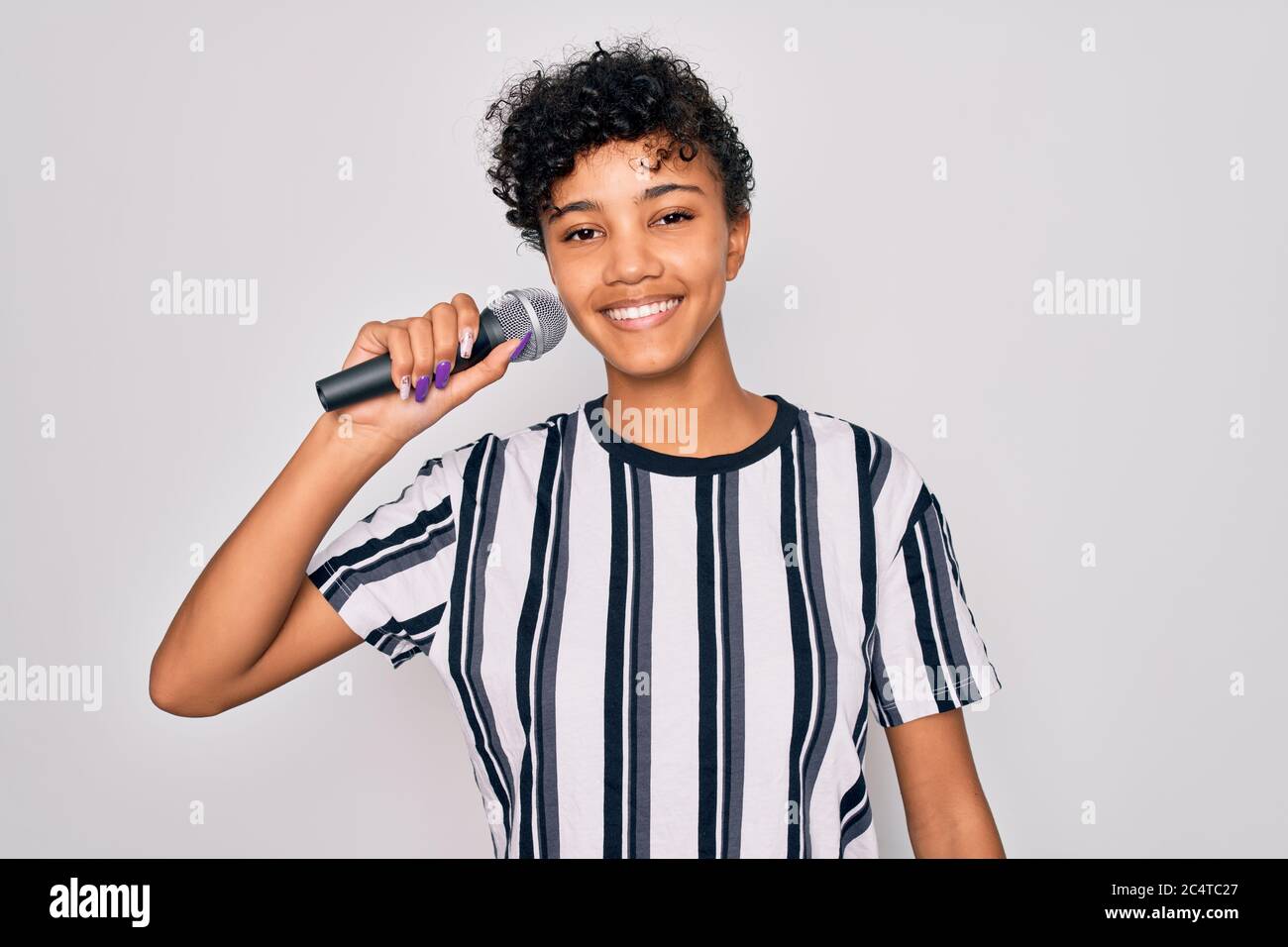 Beautiful african american afro singer woman singing using microphone ...