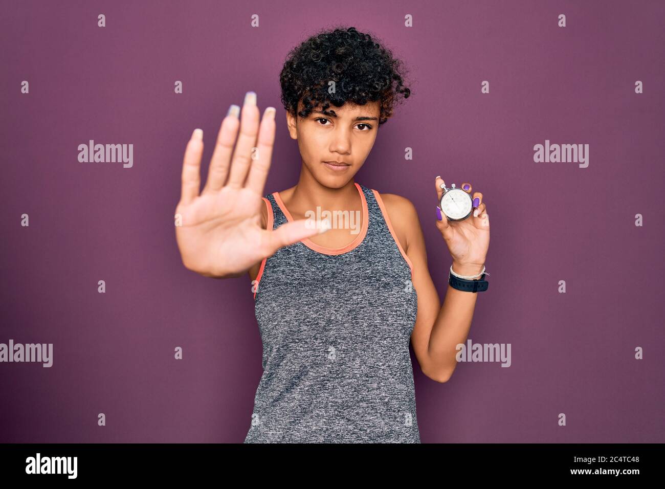 Young beautiful african american sporty woman holding stopwatch over ...
