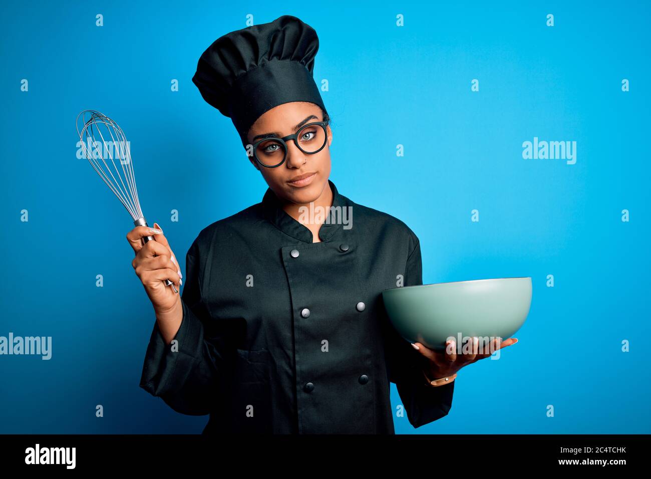 Young african american chef girl wearing cooker uniform and hat using ...