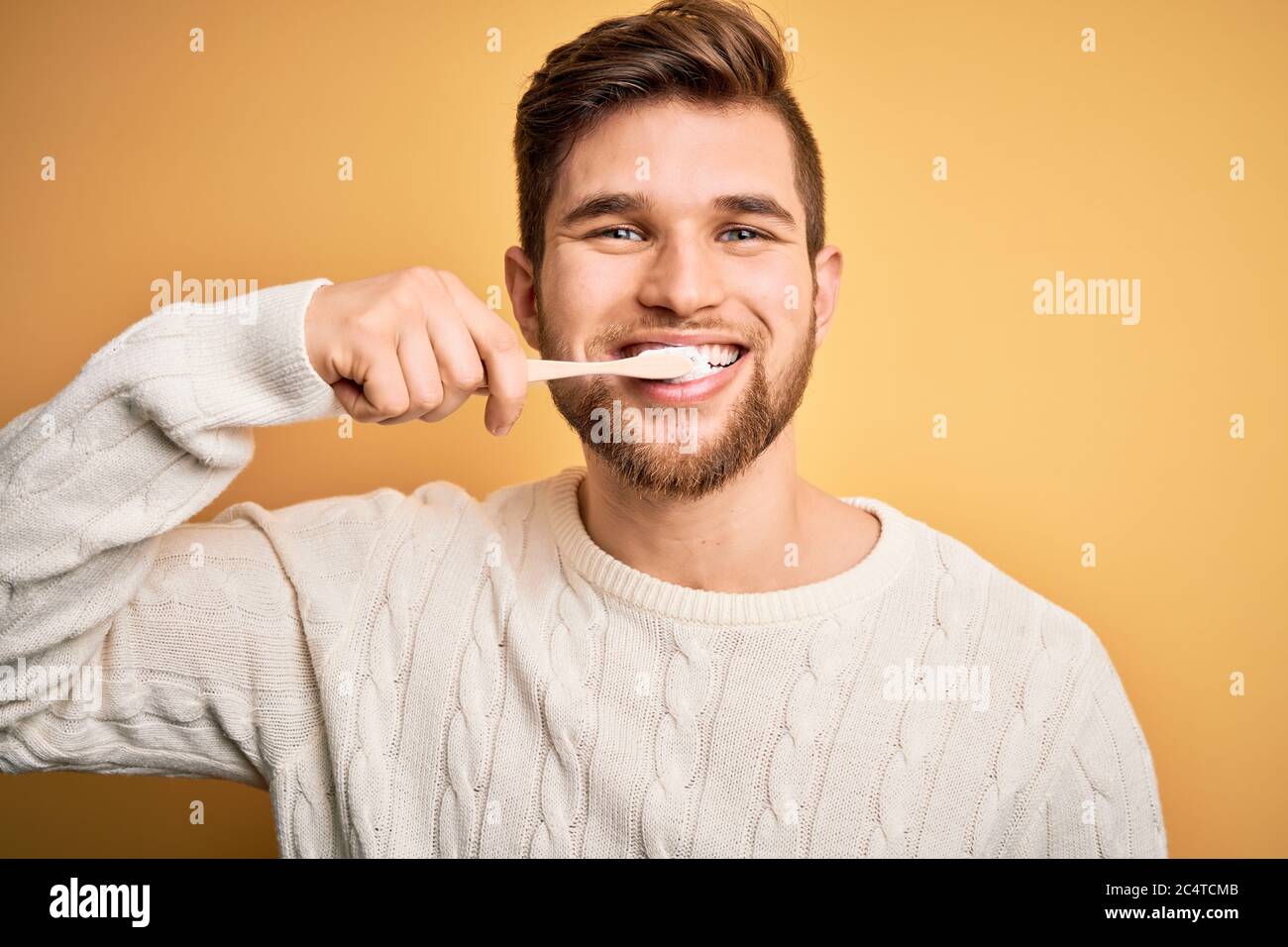 Young handsome caucasian man brushing his teeth using tooth brush and ...
