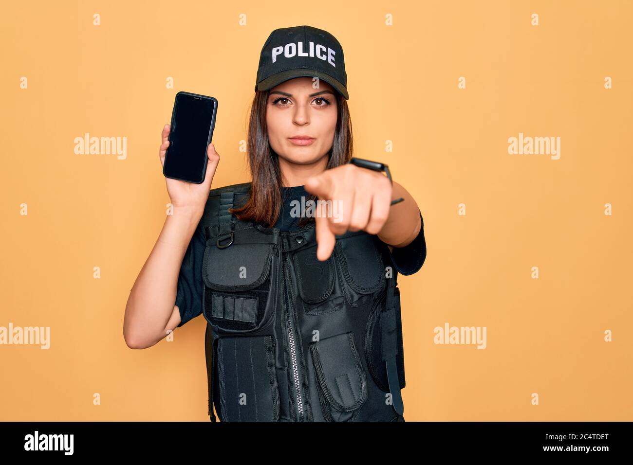 Beautiful brunette policewoman wearing police uniform holding ...
