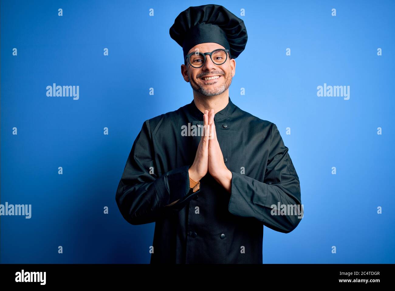 Young handsome chef man wearing cooker uniform and hat over isolated ...