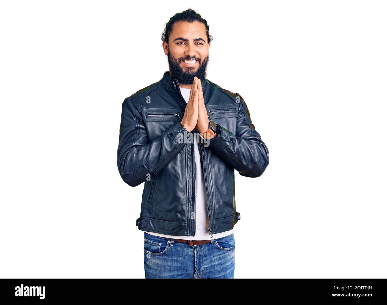 Young arab man wearing casual leather jacket praying with hands together asking for forgiveness ...