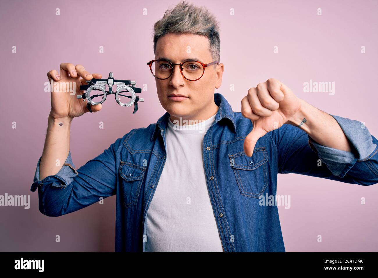 Young modern optical optomestrist man holding optometrical glasses over ...