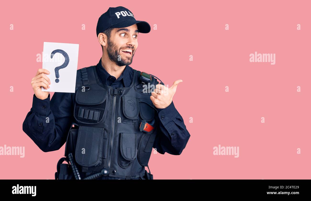 Young handsome man with beard wearing police uniform holding question ...