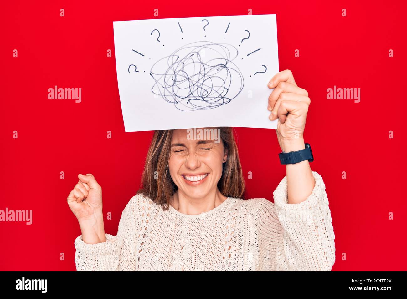Young beautiful blonde woman holding picture of chaos above head ...
