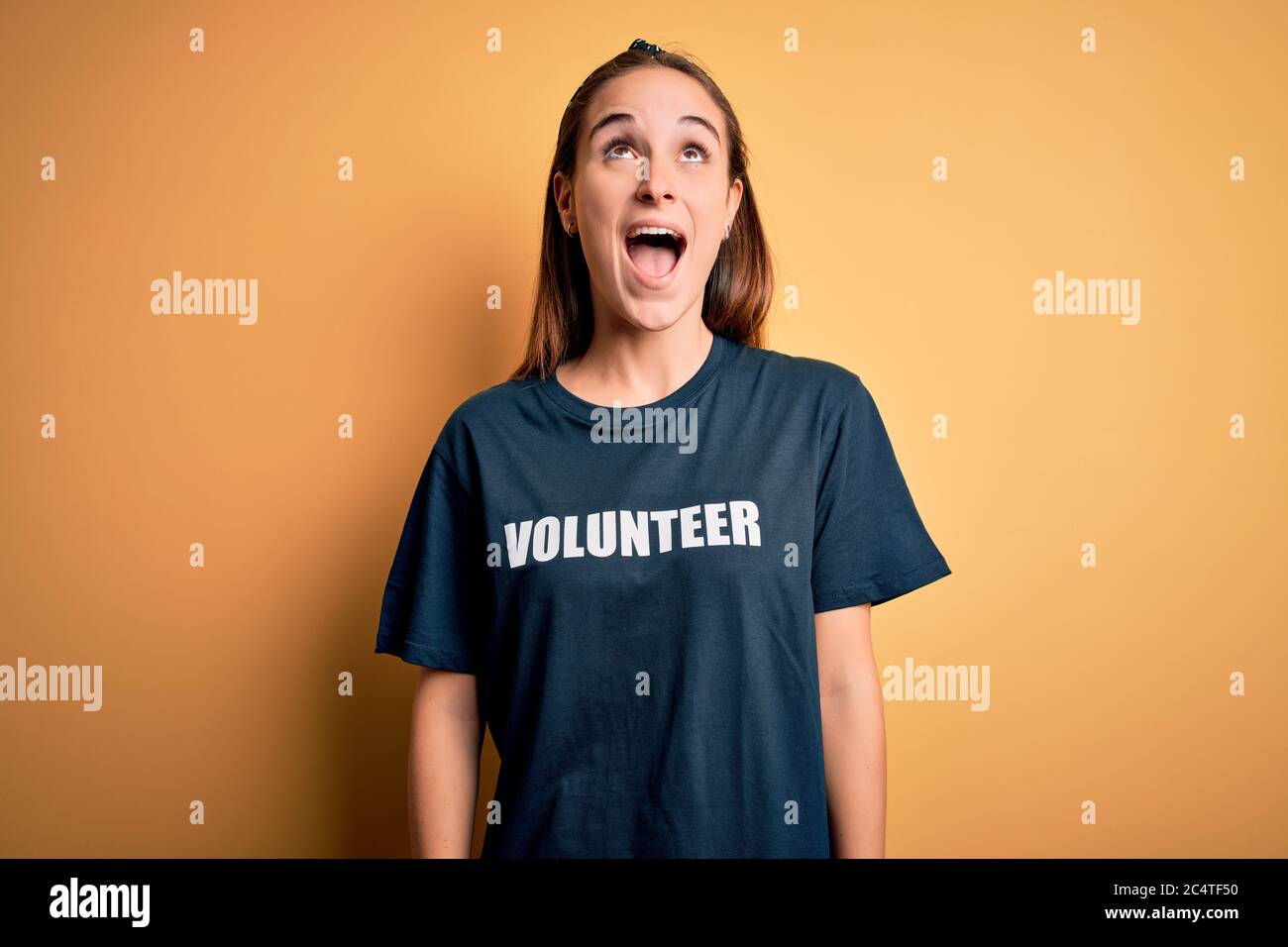 Young beautiful woman wearing volunteer t-shirt doing volunteering over ...
