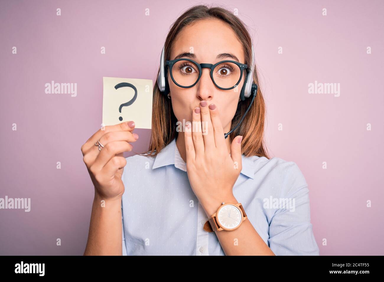 Beautiful call center agent woman working using headset holding ...