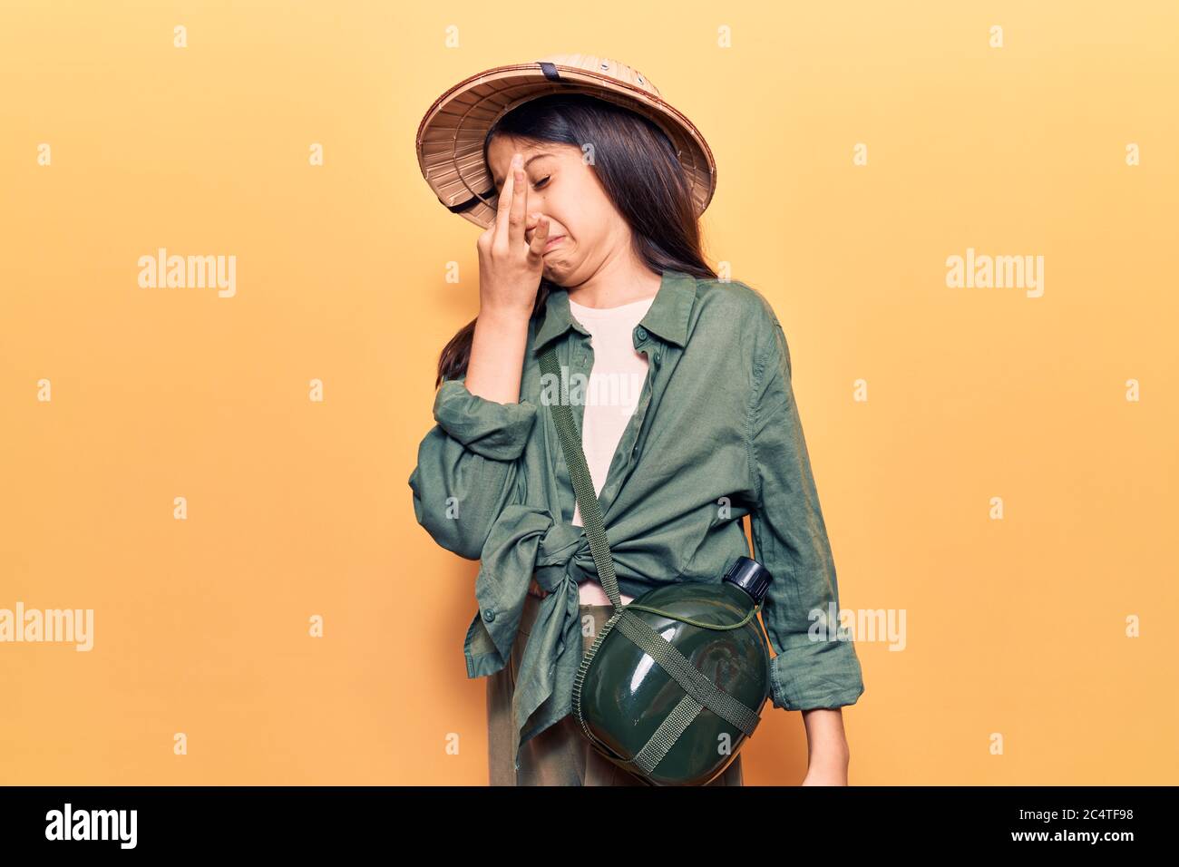 Beautiful child girl wearing explorer hat smelling something stinky and ...