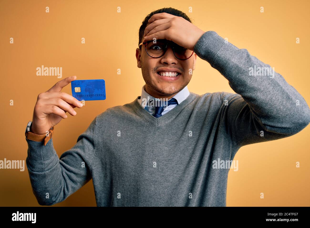 Young brazilian businessman holding credit card money over isolated ...