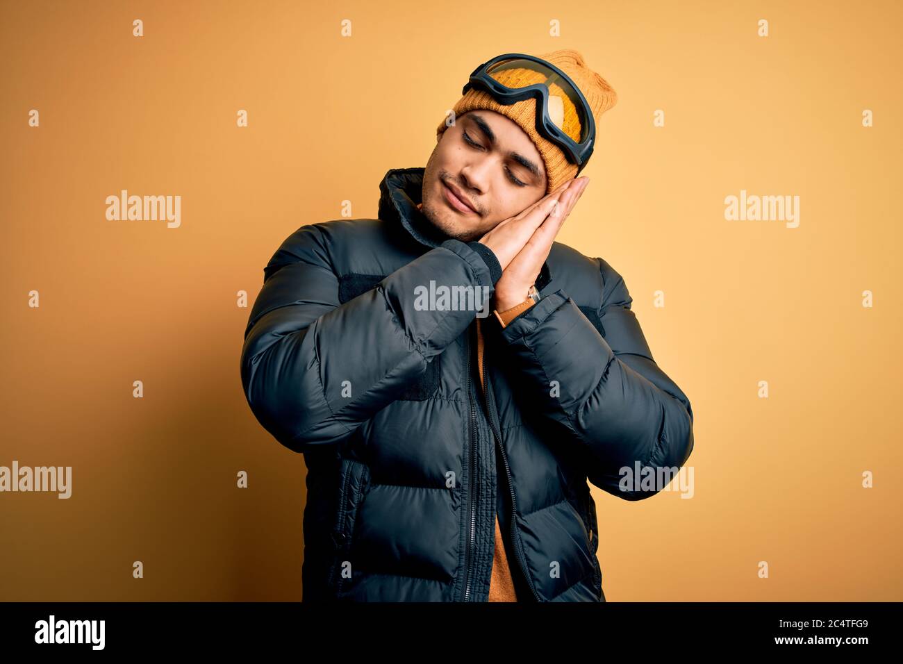 Young brazilian skier man wearing snow sportswear and ski goggles over ...
