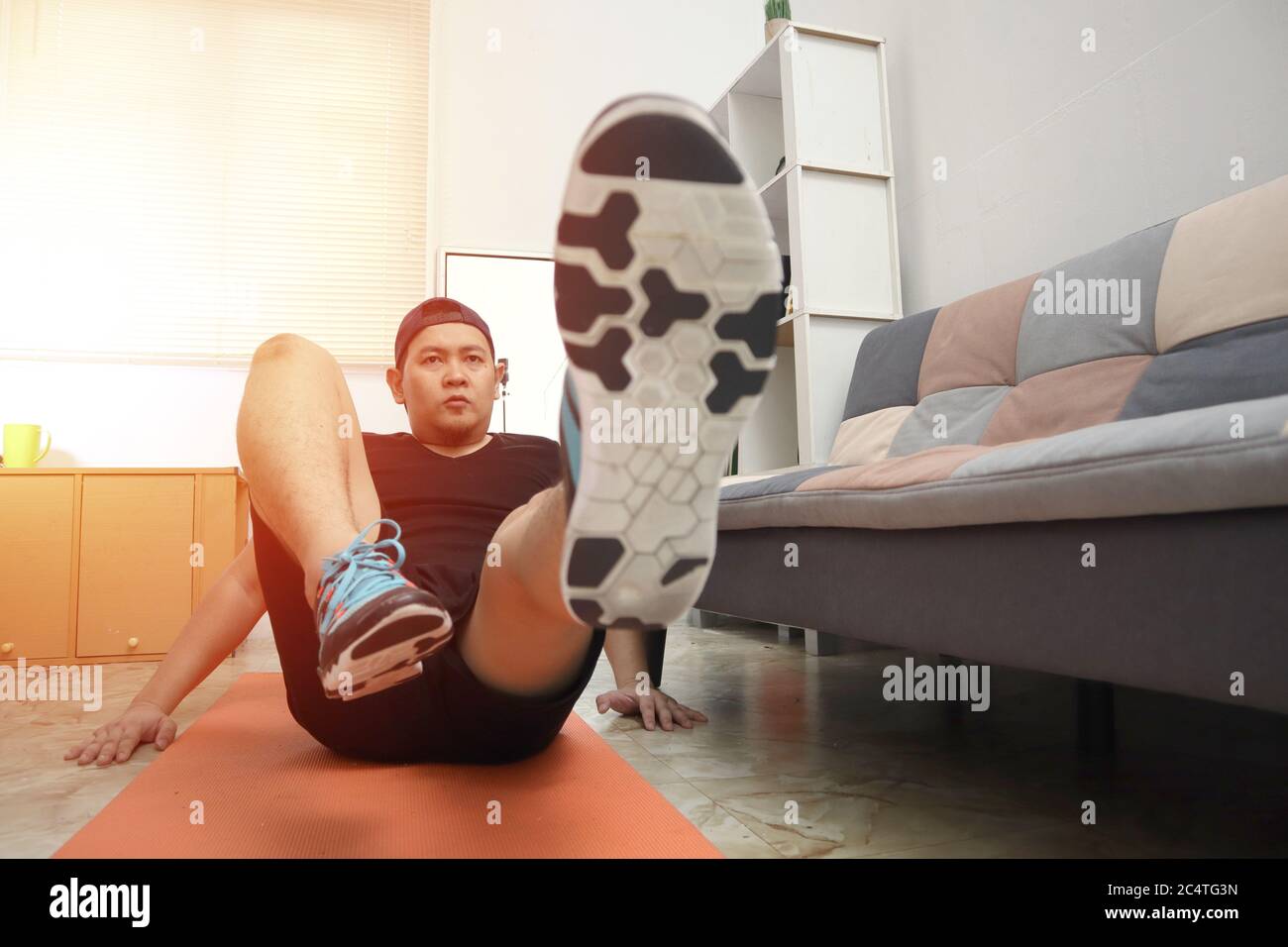 Asian male doing exercise at home to stay healthy on new normal ...