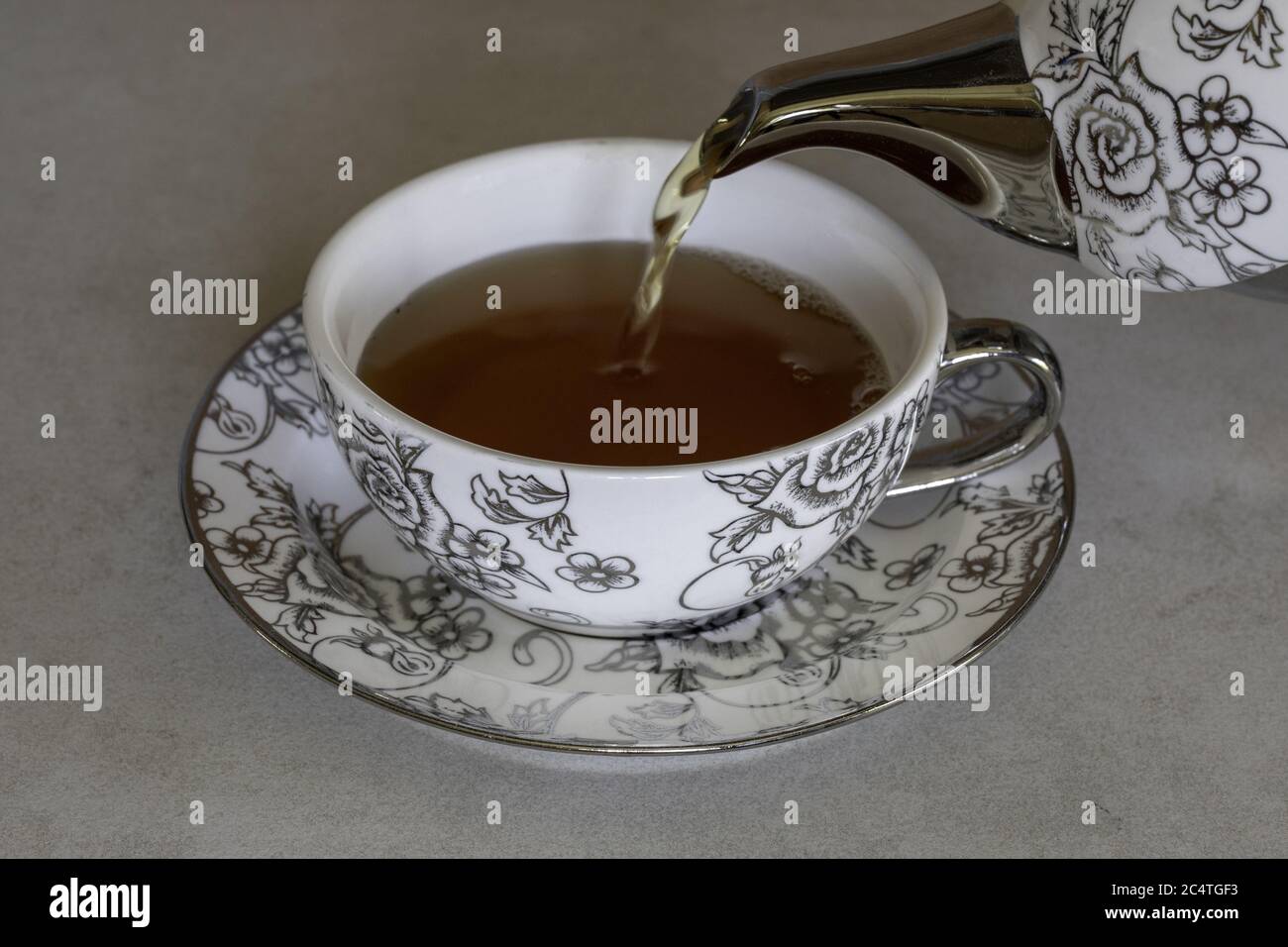 High angle shot of a classic teacup with poring black tea Stock Photo ...