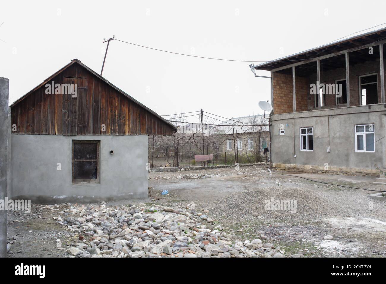 Old village with old gray houses and dry bare trees Stock Photo - Alamy