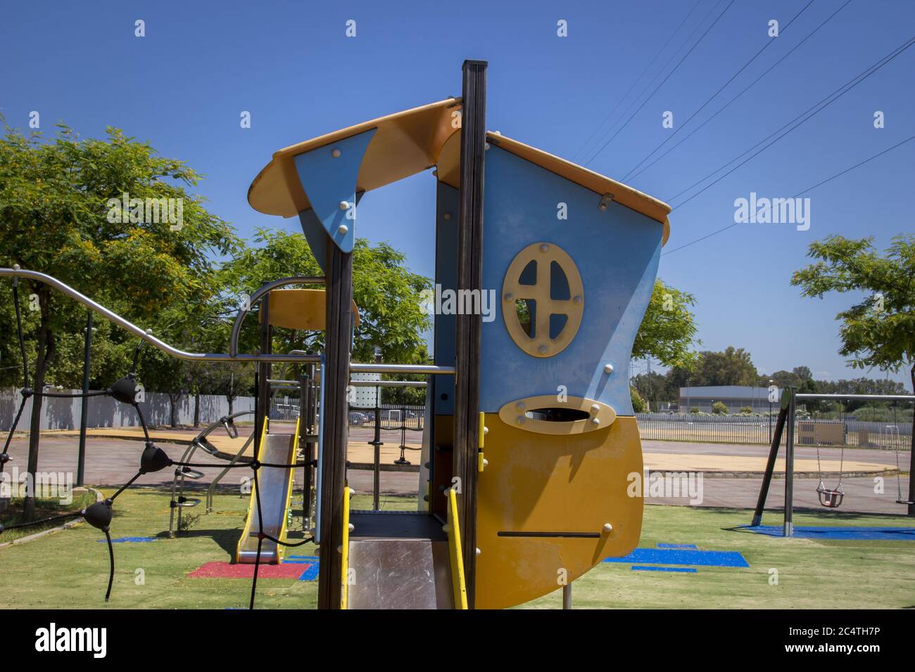 Metal slide surrounded by trees in the playground Stock Photo - Alamy