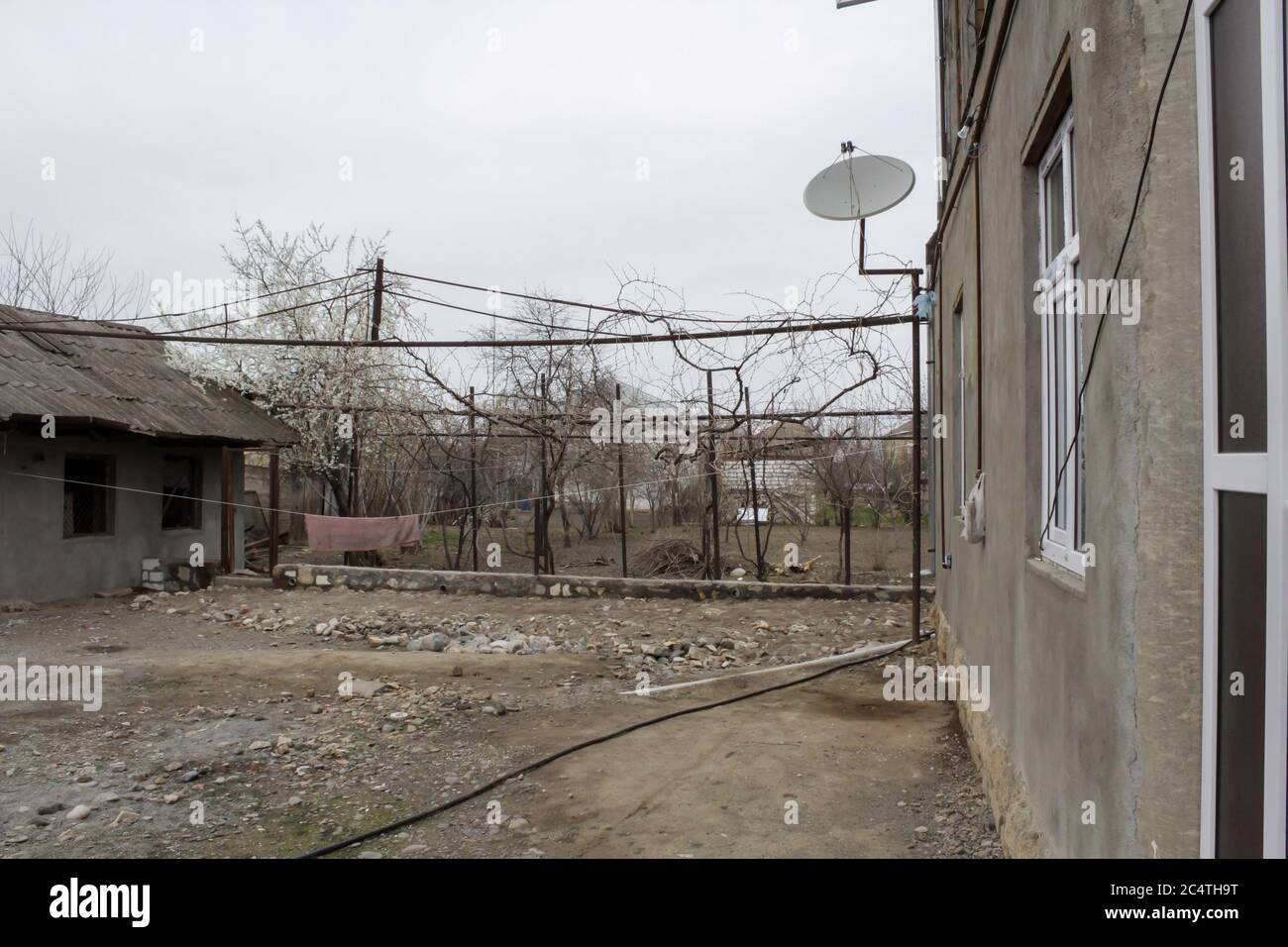 Old village with old gray houses and dry bare trees Stock Photo - Alamy