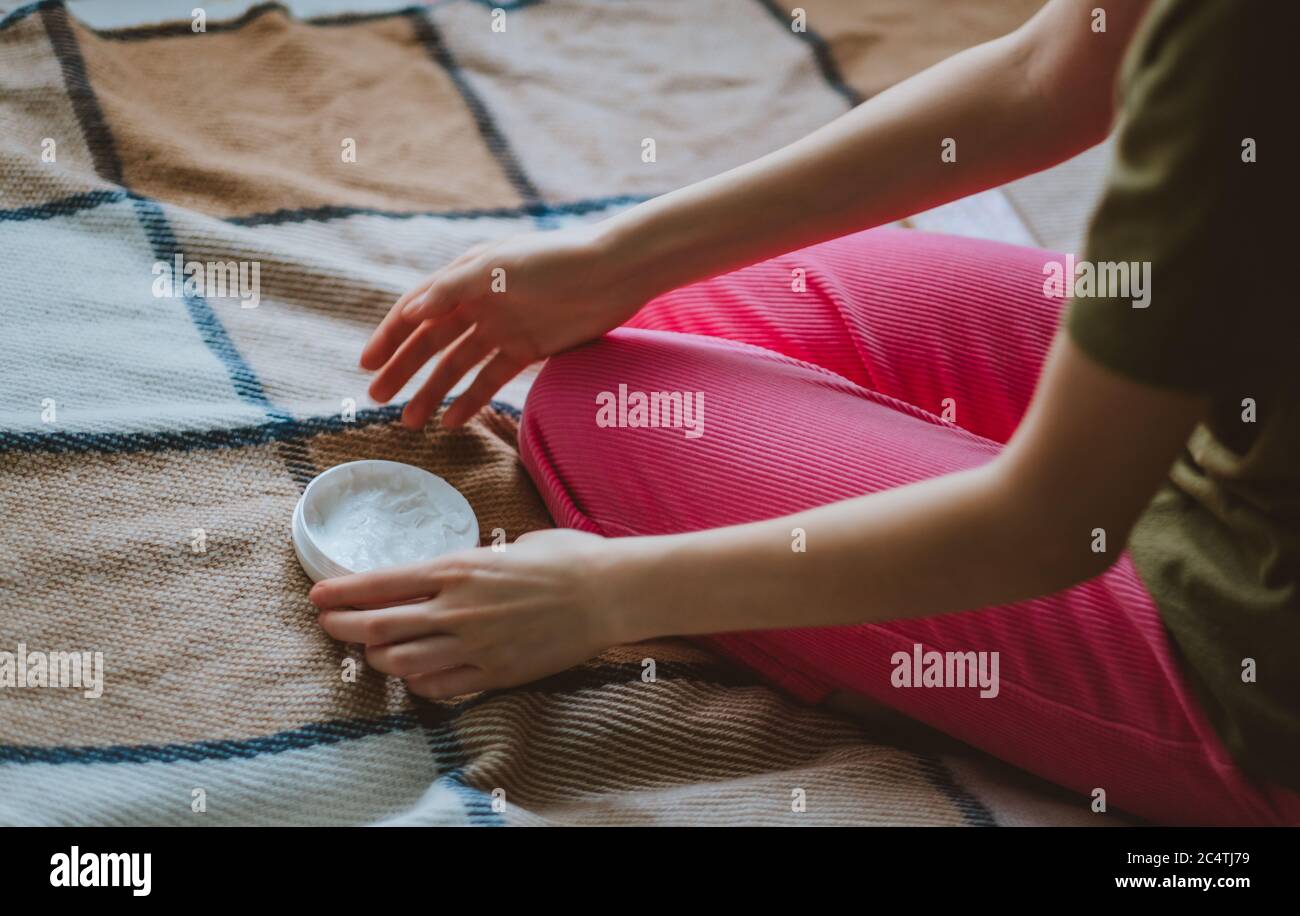Young female uses body cream Stock Photo - Alamy