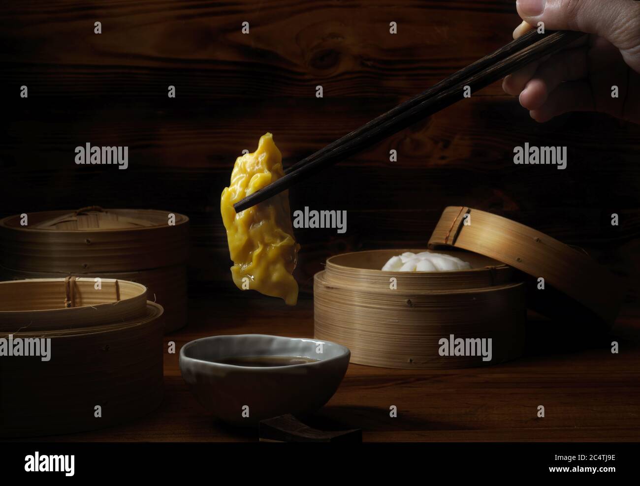 Close up view of female with chopstick ready to eat steamed dumplings ...