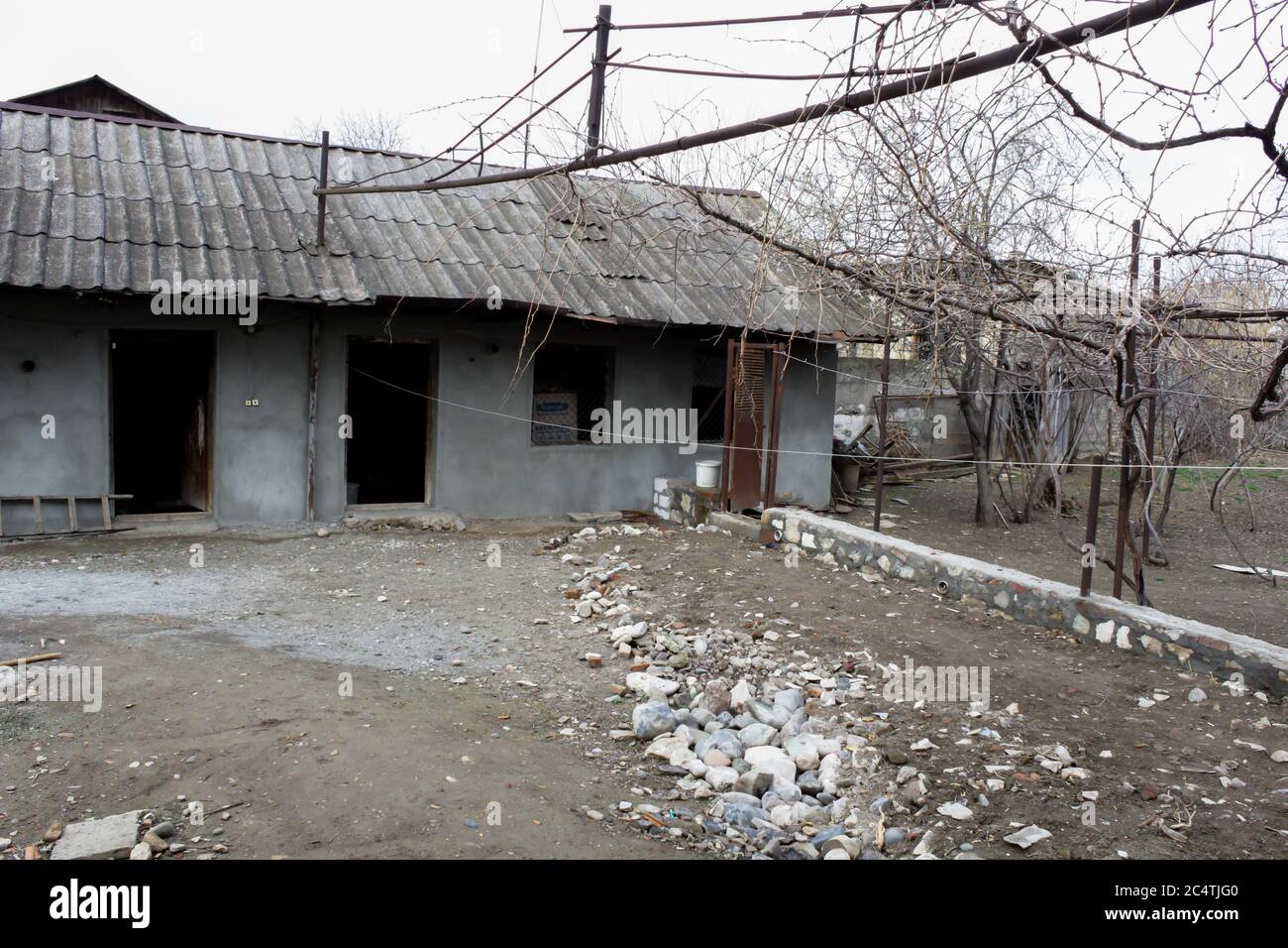 Old village with old gray houses and dry bare trees Stock Photo - Alamy