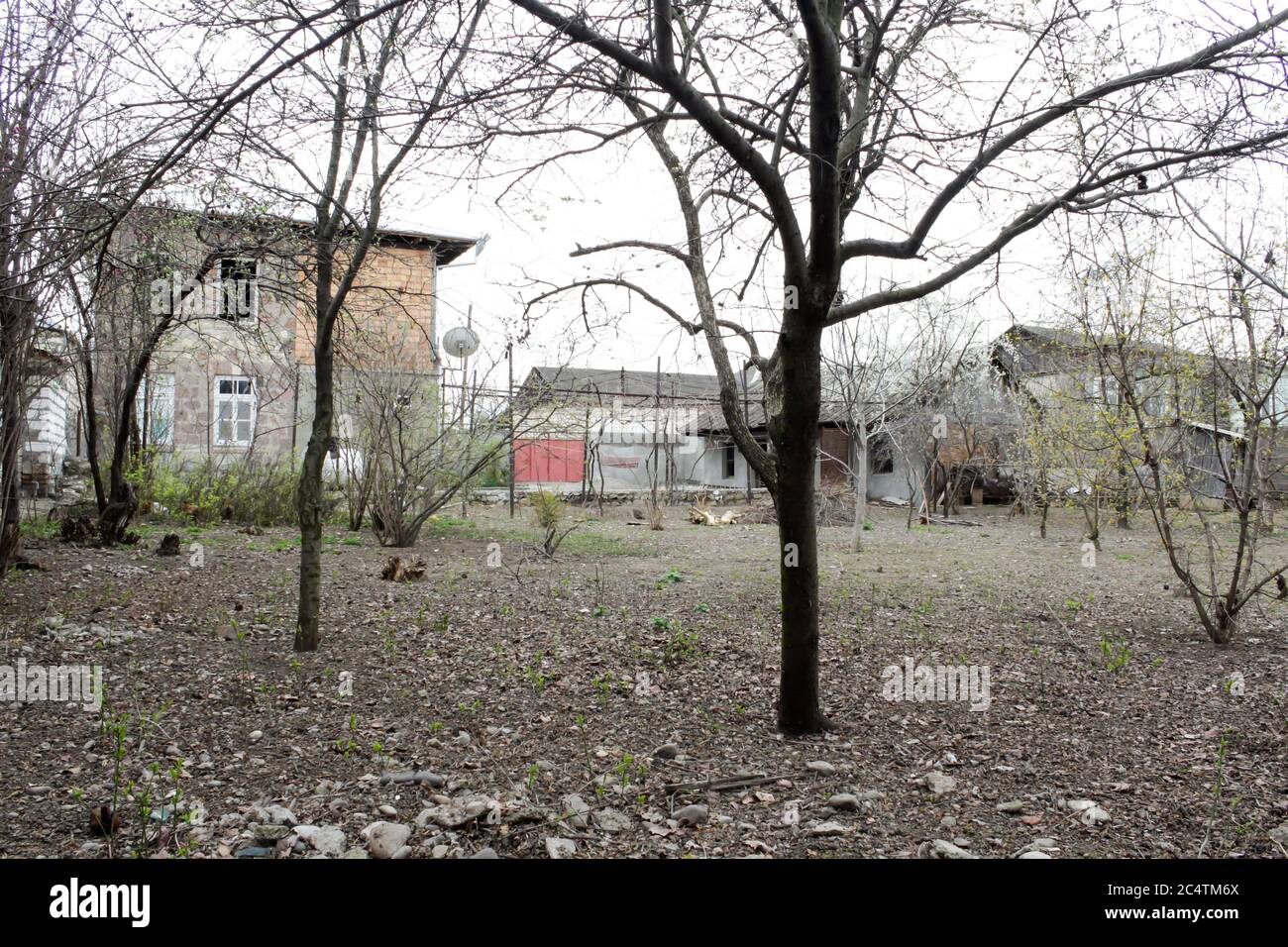 Old village with old gray houses and dry bare trees Stock Photo - Alamy