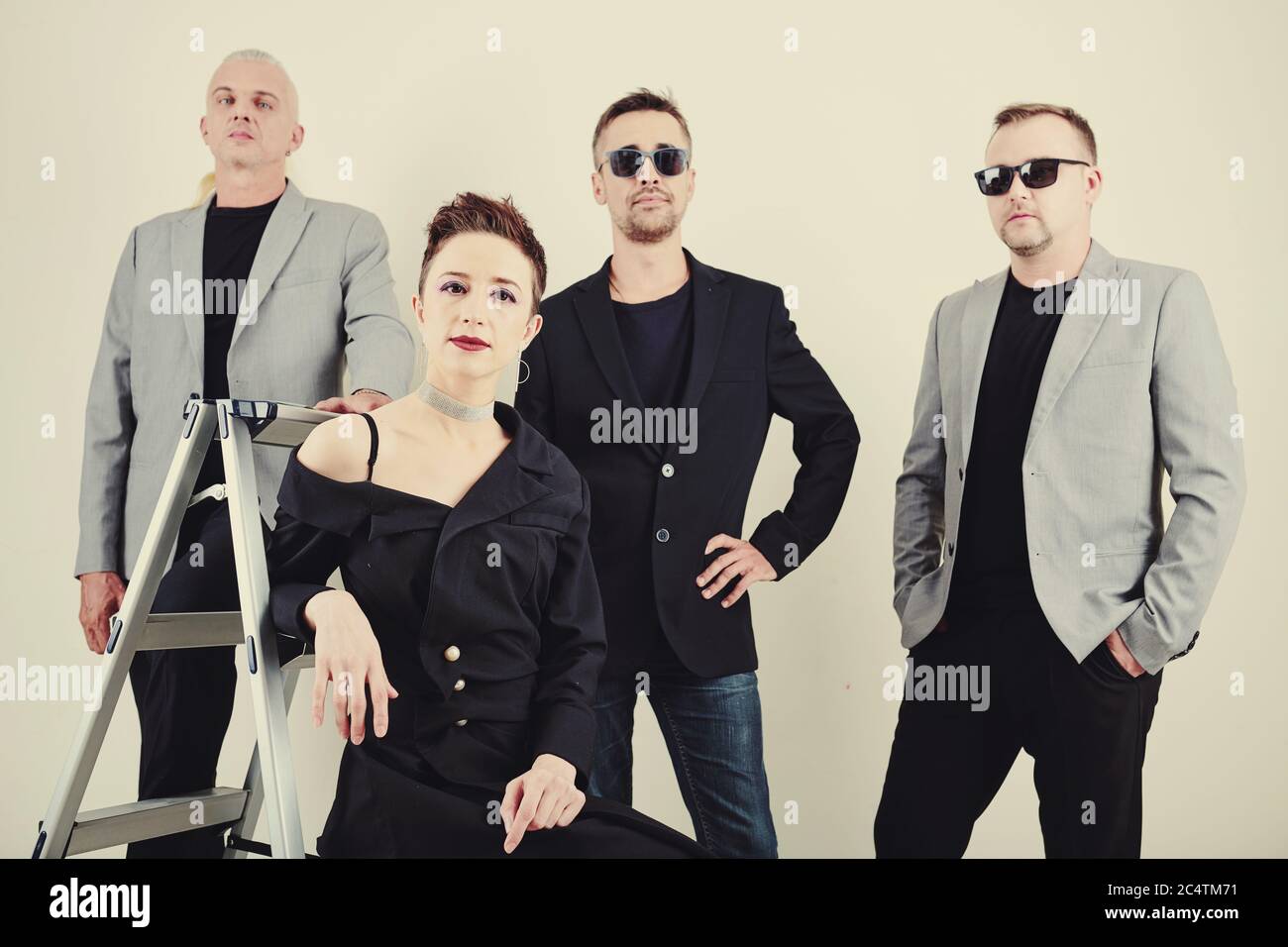 Stylish music band posing in studio for poster Stock Photo - Alamy