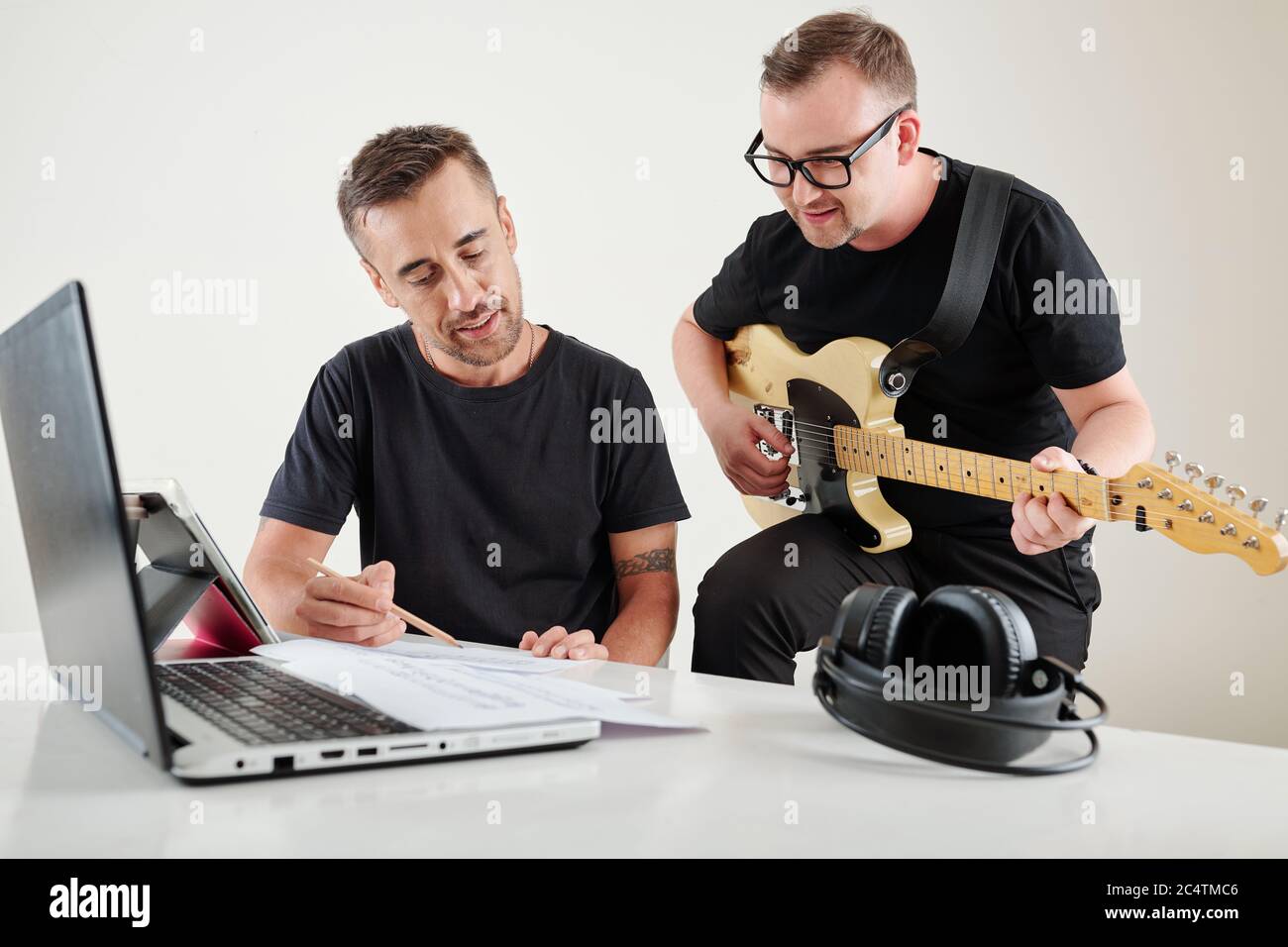 Composer and songwriter working together on new song for music band ...
