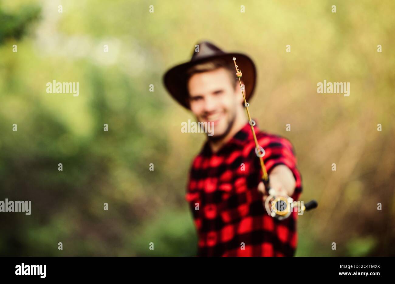 fishing rod selective focus. happy fisherman in hat blurred. western ...
