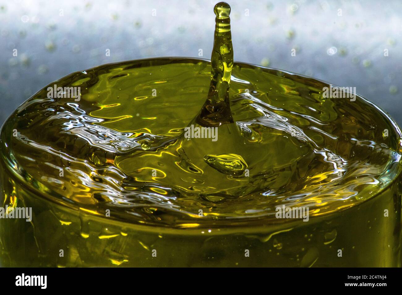 Yellow juice splashing and spilling from the glass Stock Photo - Alamy