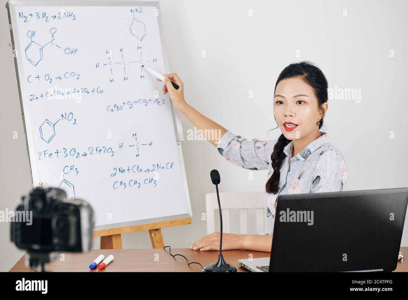 Young Asian chemstry teacher filming video for her class and explaining ...