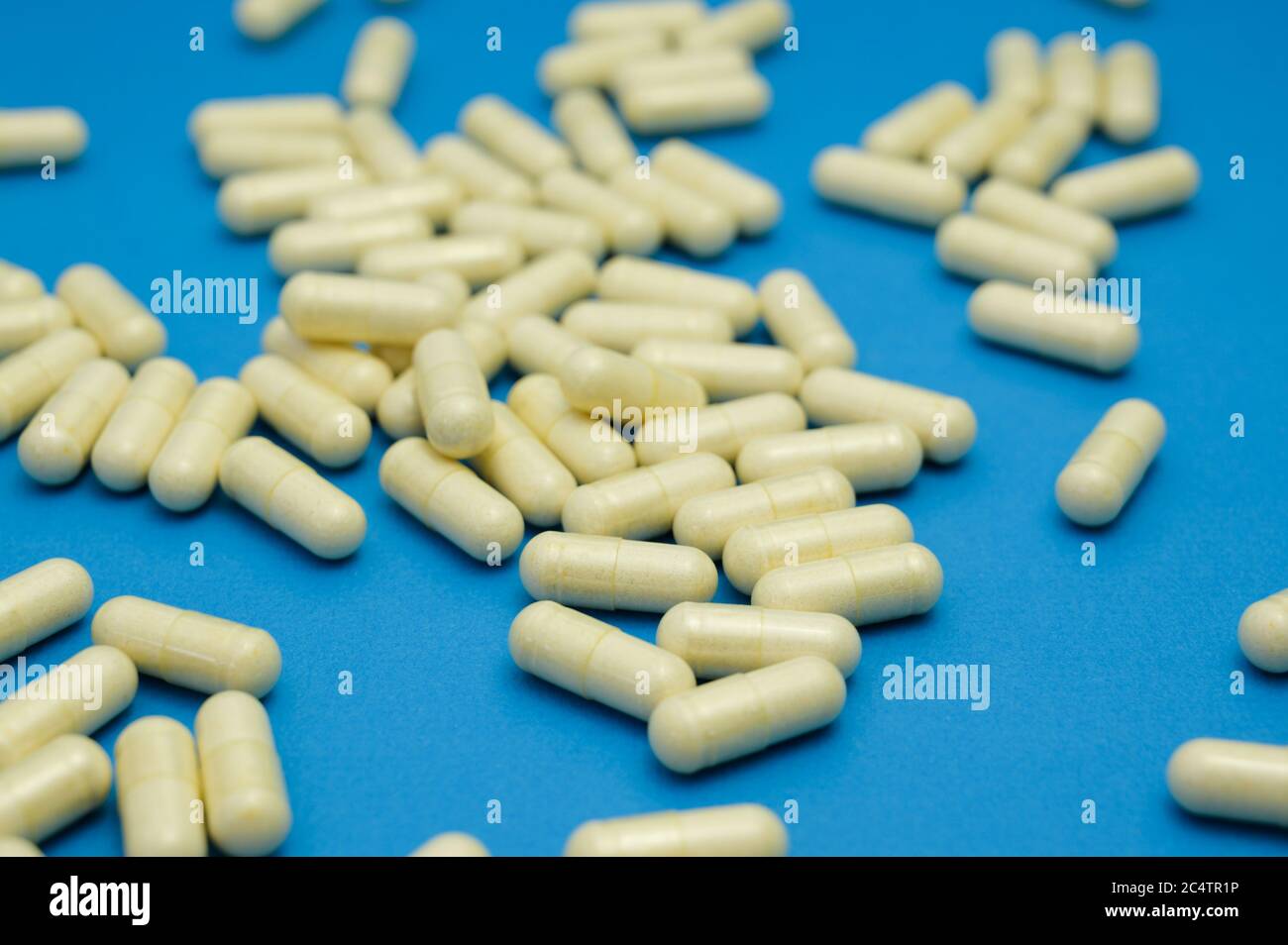 many capsules of drug multivitamin on blue surface Stock Photo - Alamy