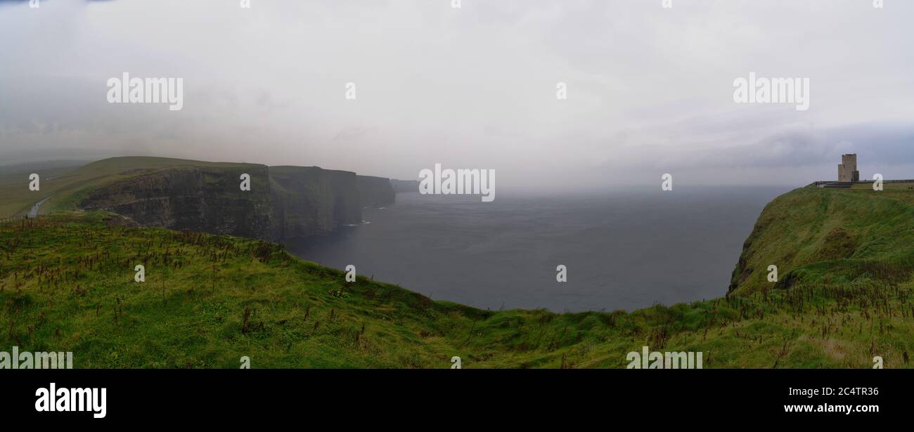 Panoramic view of the cliff of Moher with rain and fog Stock Photo - Alamy