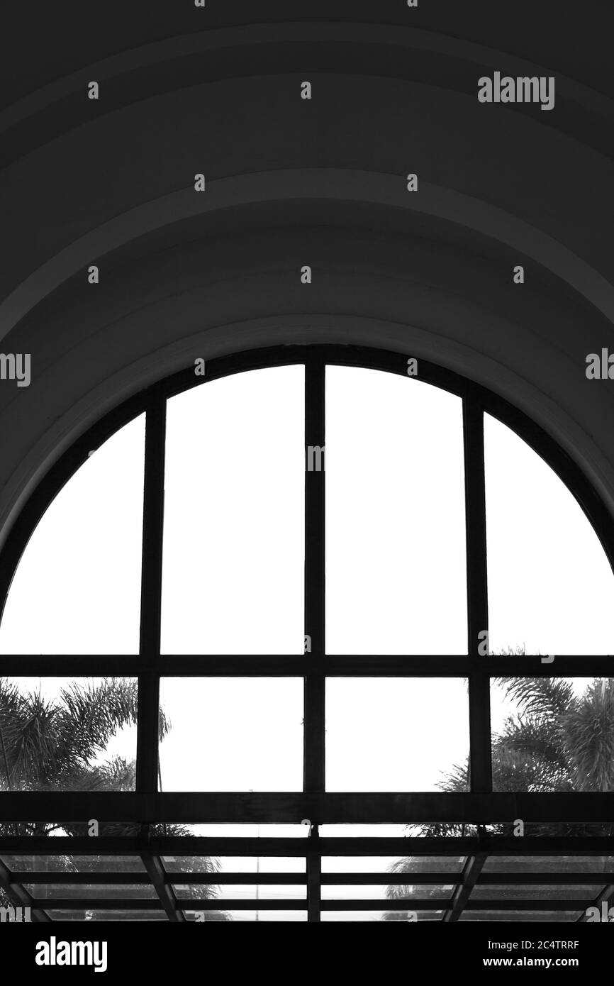 Vertical grayscale shot of an interior with a window arc Stock Photo ...
