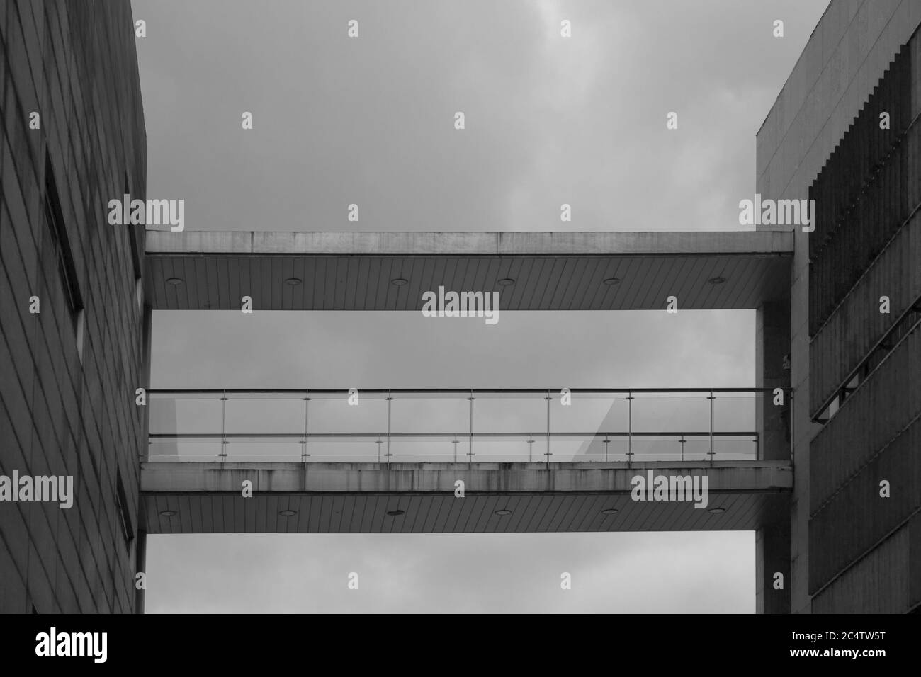 Grayscale shot of an elevated bridge between two buildings Stock Photo ...