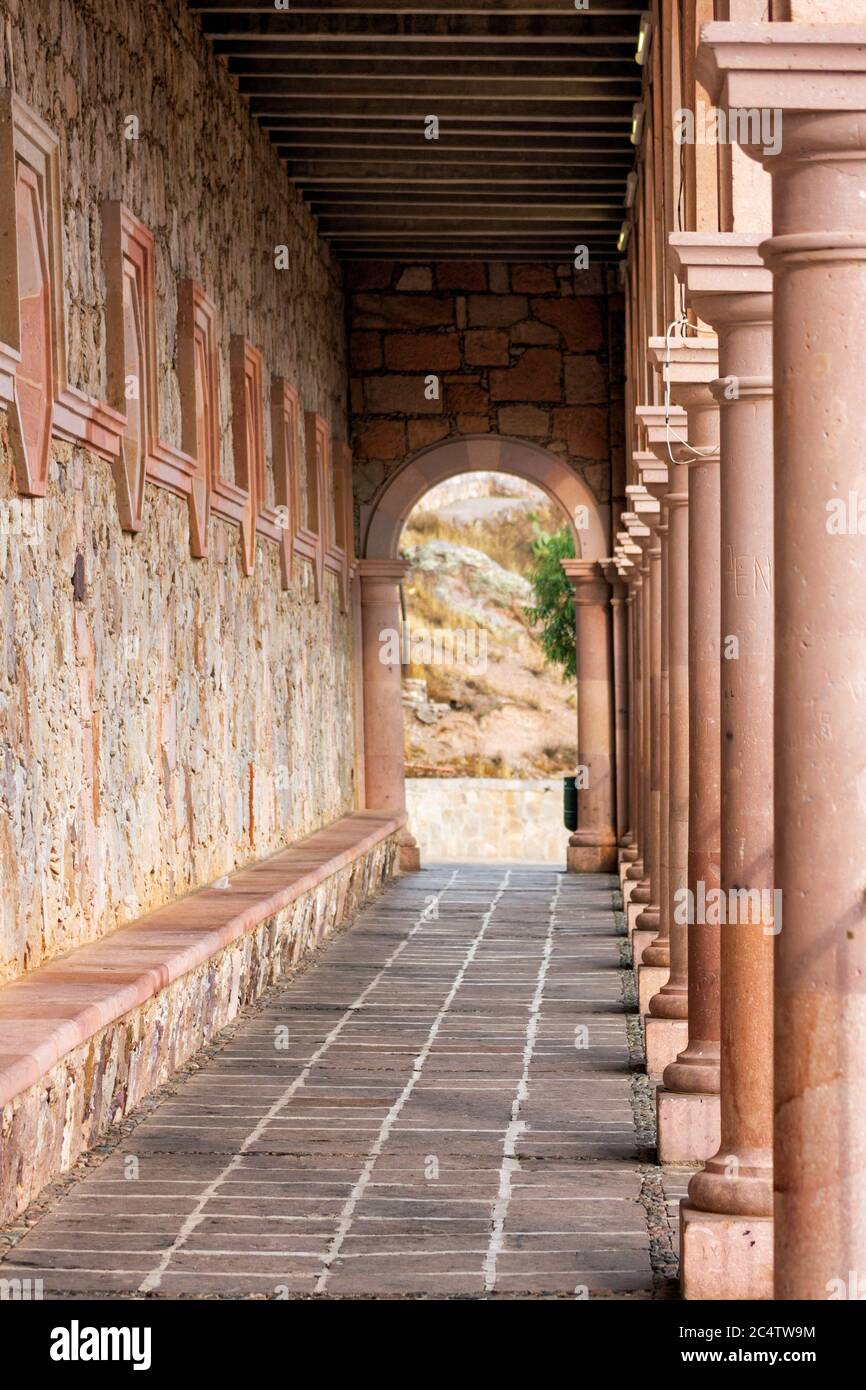 Vertical image of the corridor of a temple lined with columns leading ...
