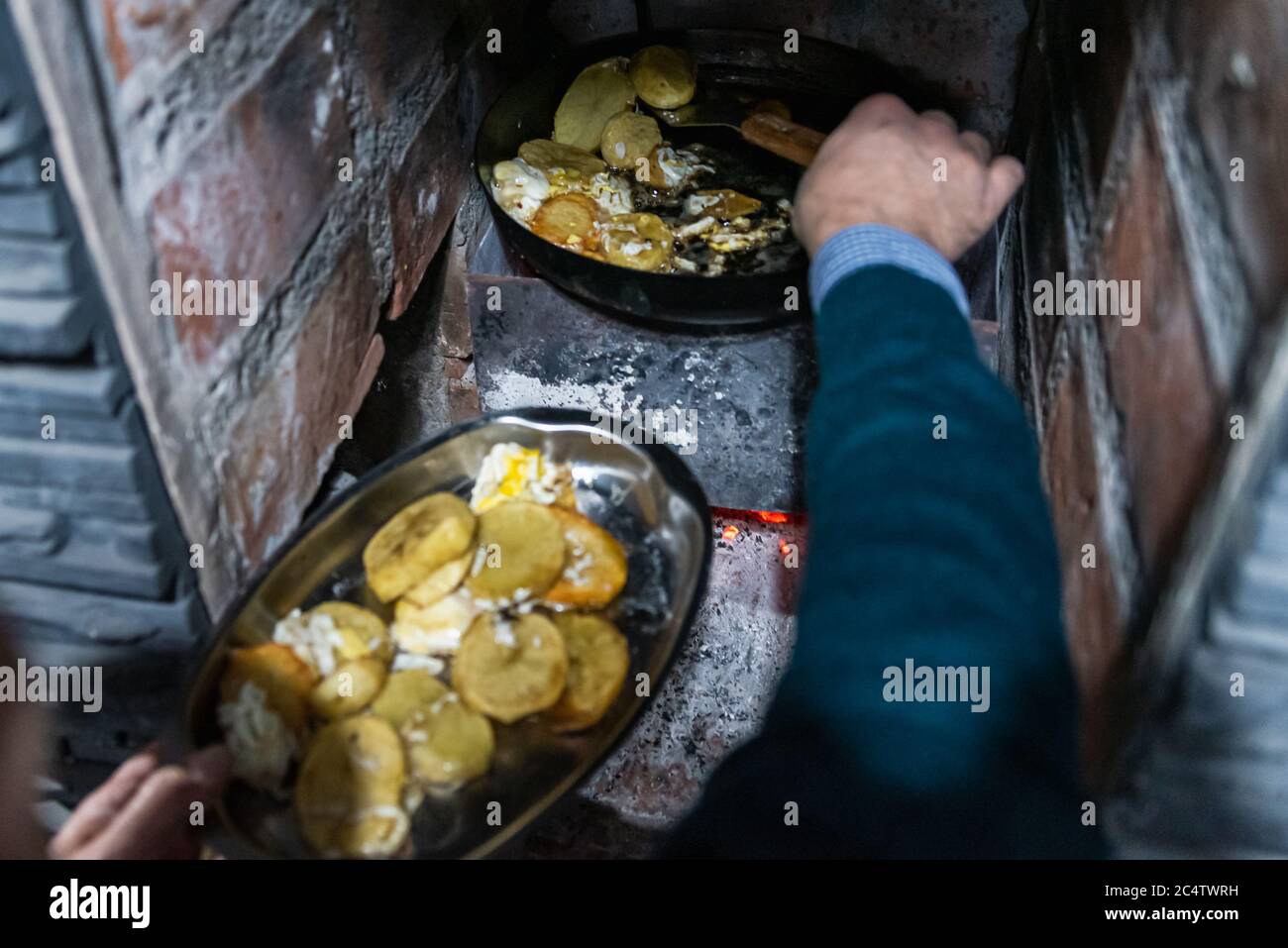man cooking fried eggs with potatoes in frying pan, top view, selective ...