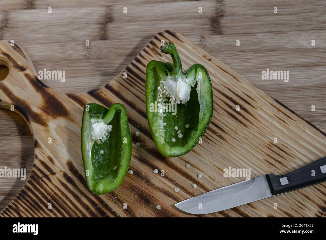 A high angle closeup shot of a green pepper cut into two pieces on the ...
