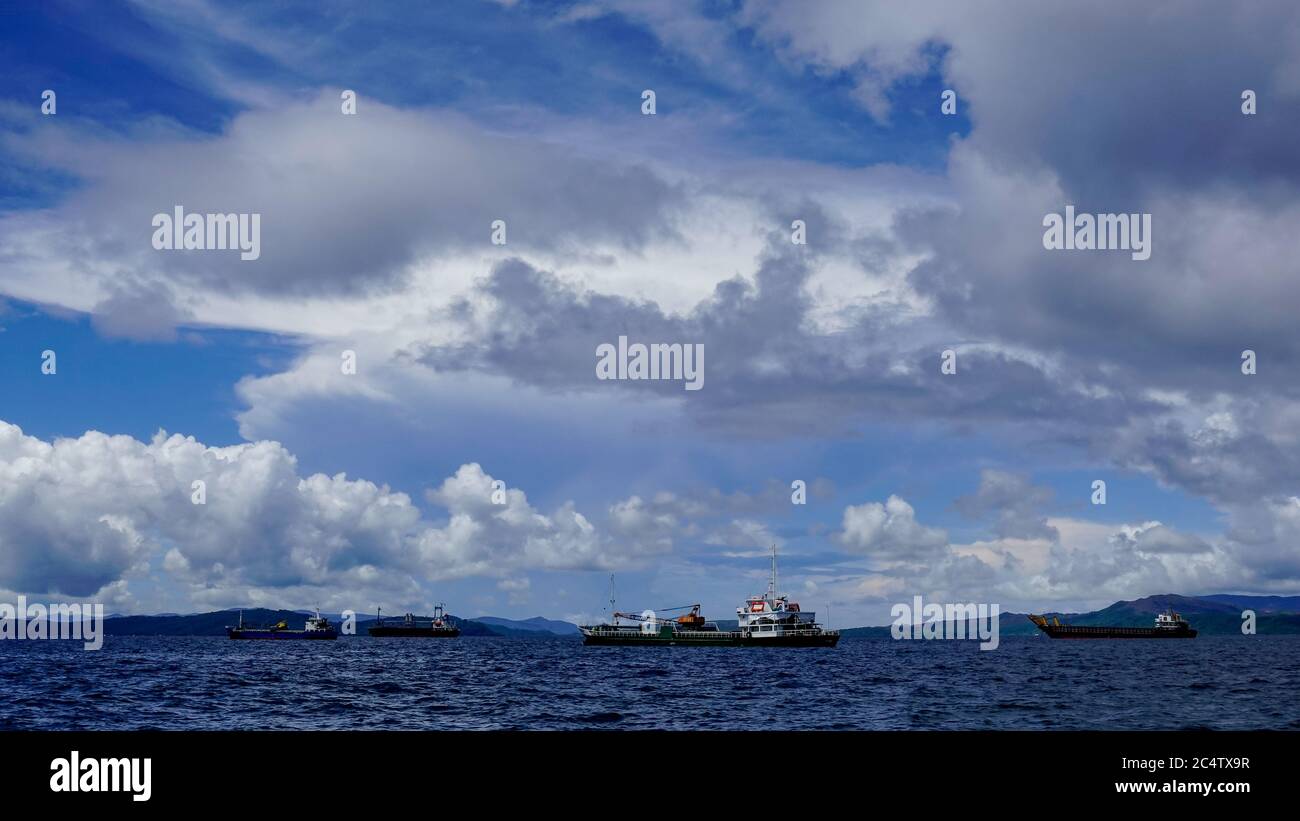 Mining Barges on the sea under a blue cloudy sky in Surigao Del Norte ...